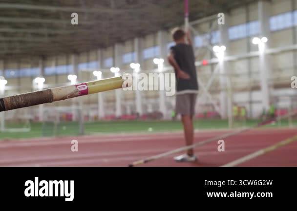 Young male athletes preparing for a pole vault jump during a training ...