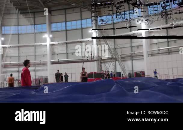 Young male athlete successfully pole vaulting over a high bar during an ...
