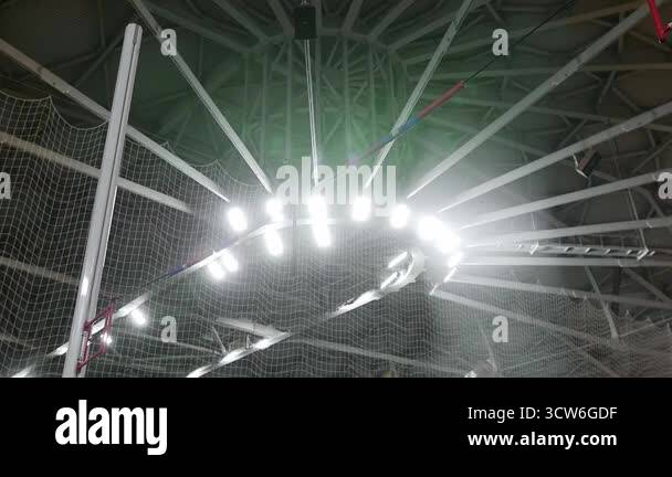 Athletic man performing a pole vault jump over a high bar during an ...