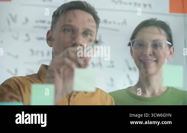 Two business colleagues are actively engaged in a brainstorming session ...