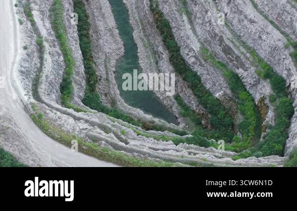 Mining area forming deep spiral channels with green water at bottom ...