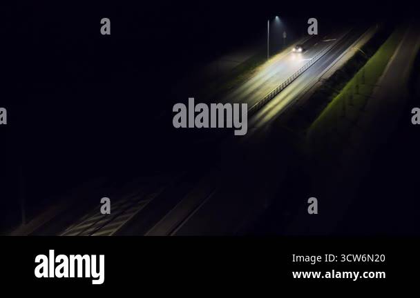 Car driving on road at night, headlights lighting way. Vehicle moving ...