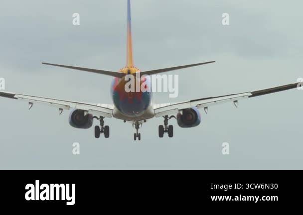 Jet passenger plane landing on wet runway during cloudy weather ...
