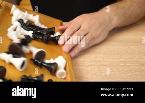 Chess pieces spill off the board and fall onto the table Stock Video ...