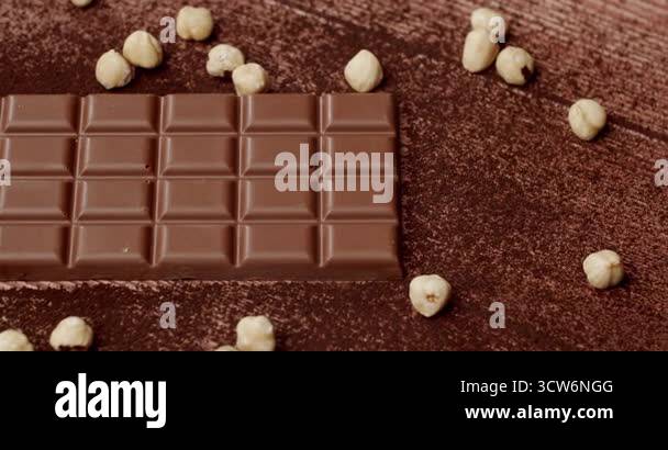 Close-up of a delicious chocolate bar with whole hazelnuts on a cocoa ...