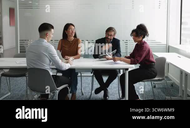 Diverse business team talking at meeting table, brainstorming on ideas ...