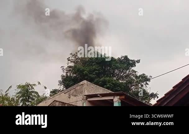 Thick Black Smoke Rising into the Sky from Behind a Building.The dark ...