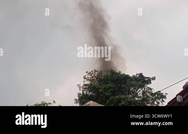 Thick Black Smoke Rising into the Sky from Behind a Building.The dark ...