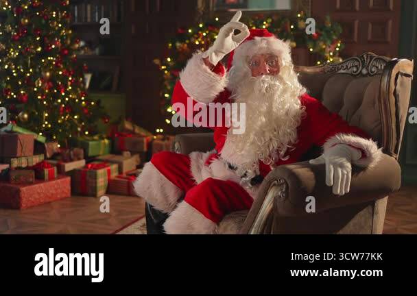 Merry Christmas. Happy Santa Claus sitting in chair in festive living ...