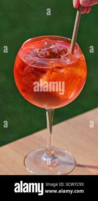 glass of fresh refreshing aperol spritz cocktail against a green ...