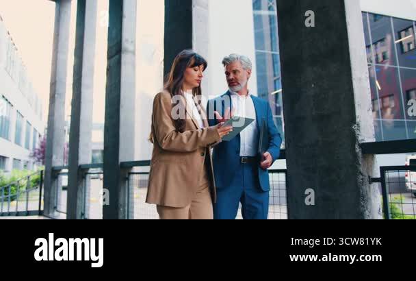 Confident business professionals in formal suits walking and talking ...