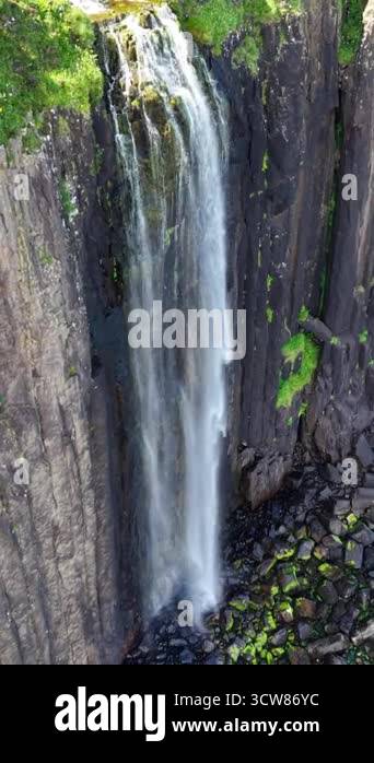 Experience the breathtaking beauty of a waterfall cascading down rugged ...