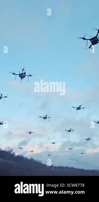 Swarm of Drones Flying at Dusk. A group of drones hovering in the sky ...