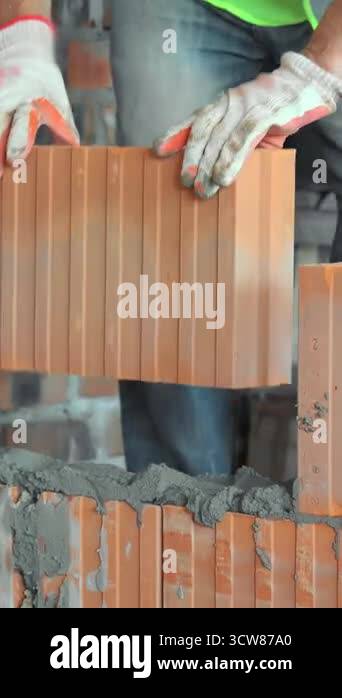 Construction worker placing brick on a wall, A construction worker in ...
