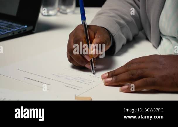 Close up of a man signing work contract with human resources manager ...