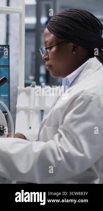 Vertical Video Black female expert analyzing samples in chemistry lab ...