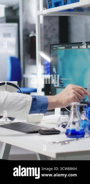 Vertical Video Chemist in biolab observes computer with fascination and ...