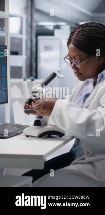 Vertical Video African american woman analyzing molecular samples in a ...