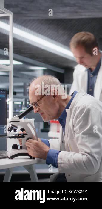 Vertical Video Laboratory with old male scientist observing specimen ...