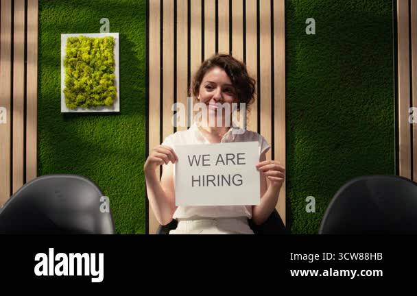 Human resources employee displaying signs for recruiting as part of ...