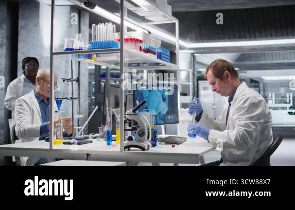Male expert using pipette to transfer matter in a jar during research study in the laboratory ...