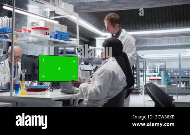 Chroma key display on monitor next to diverse experts in chemistry lab ...