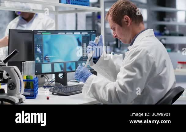 Male scientist handles pipette with droplet over jar during procedure ...
