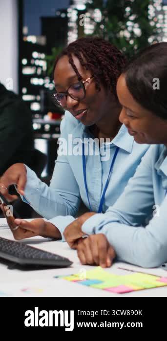Vertical Video Black business people working together on report writing ...