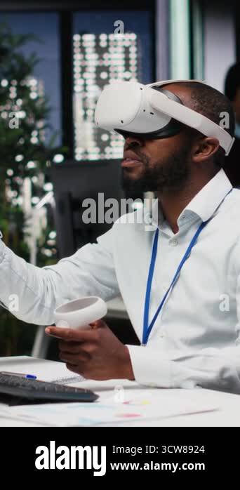 Vertical Video Black businessman using VR headset and gadgets to draft a project plan, engaged ...