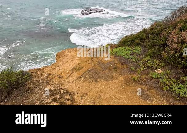 Waves crash against rugged cliffs on the Great Ocean Road, showcasing ...