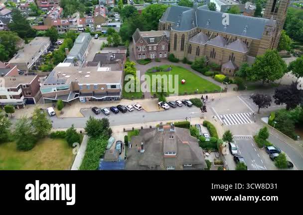 Aerial view of townscape with Gothic church, thatched-roof building ...