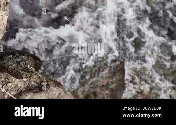 Rushing stream water over rocks, captured close-up to illustrate motion ...