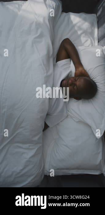 Man Lies in Bed, Stretches, Slowly Wakes Up in Morning Light. Male ...