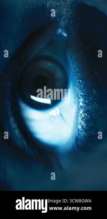 Haunting macro portrait of a human blue eye highlighted in deep shadow ...