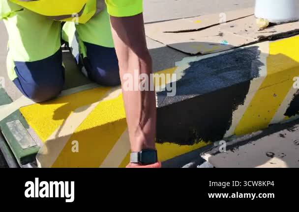 Painting safety stripes on railway platforms. Marking railway platforms ...
