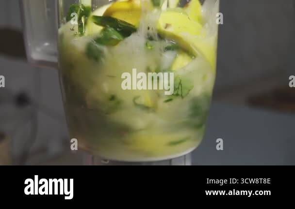 Side view of working electric blender preparing fresh green smoothie ...