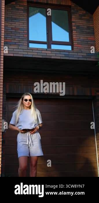 Beautiful lady demonstrating a grey t-shirt and shorts. Long angle view ...
