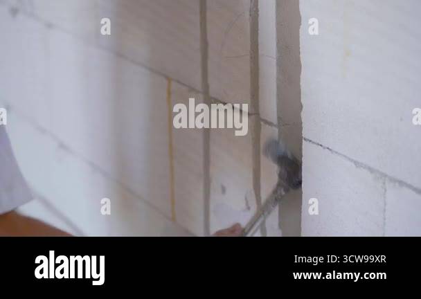 Construction worker expanding electric cable chase grooves with wall ...