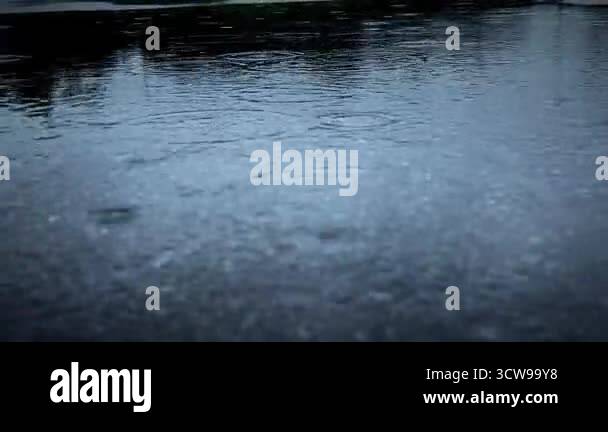 A calming and peaceful view of rain gently falling on a reflective ...