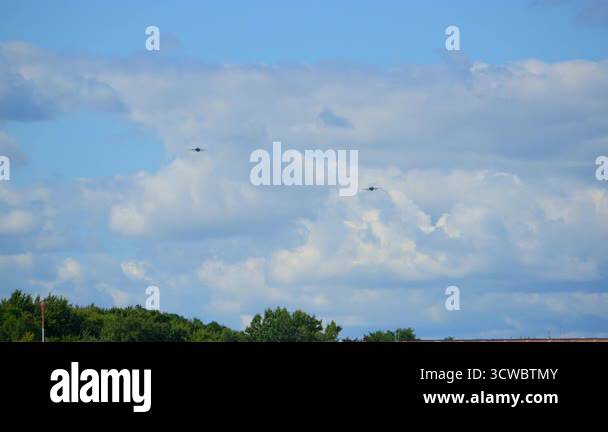 Slow motion view of approaching two F-18 fighter jets at bright cloudy ...