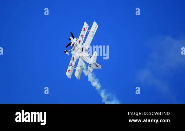 Biplane performing a dead loop maneuver during an airshow, leaving a ...