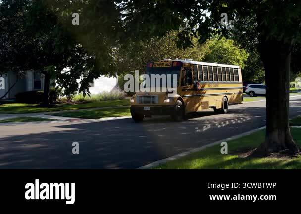 Yellow American school bus departing to school after children pick up ...
