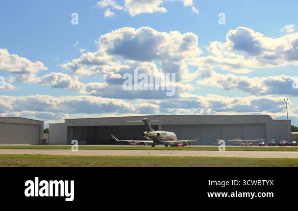 Red helicopter flying near the runway at a small airport while several ...