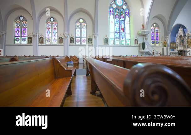 Moving along the aisle with wooden pews rows in empty church. Christian ...