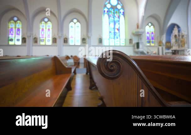 Moving along the aisle with wooden pews rows in the empty church ...