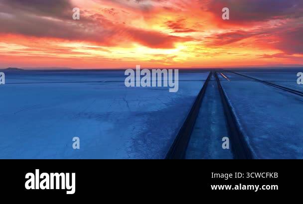 Dark lines of straight long roads cross the endless salt valley. Aerial ...