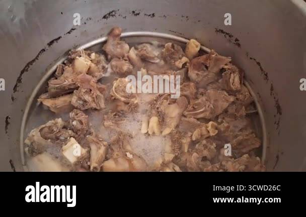 Pieces of lamb meat and bones boiling to make flavorful stock, ideal ...