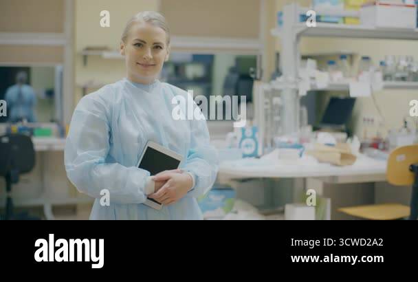 A cheerful female scientist poses confidently in a state-of-the-art ...