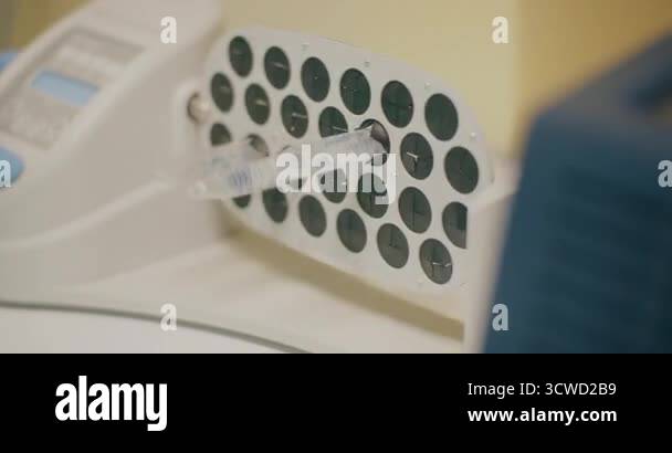 Extreme close-up of test tubes rotating in a machine, mixing solutions ...