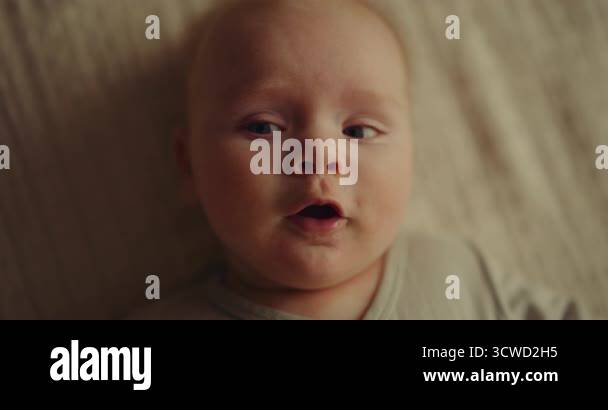 A close-up portrait of a newborn baby boy with a smiling face. Strong ...